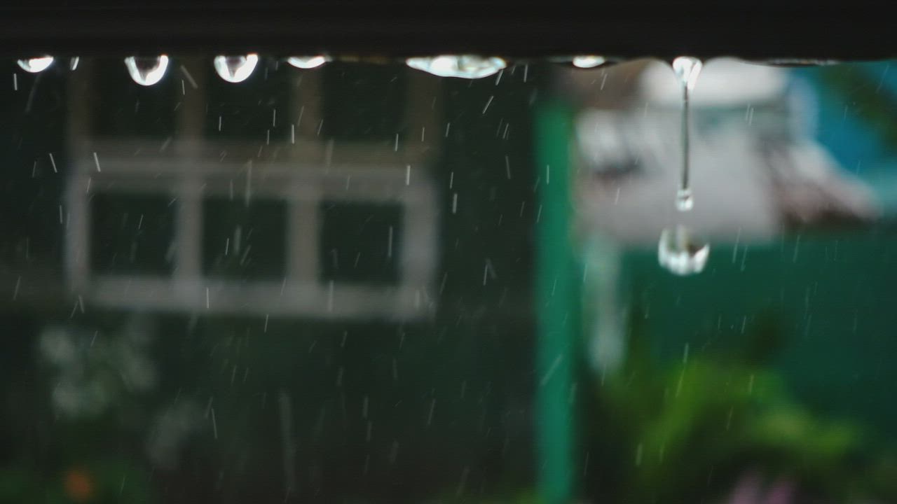 Closeup of raindrops falling from the roof - Free Stock Video
