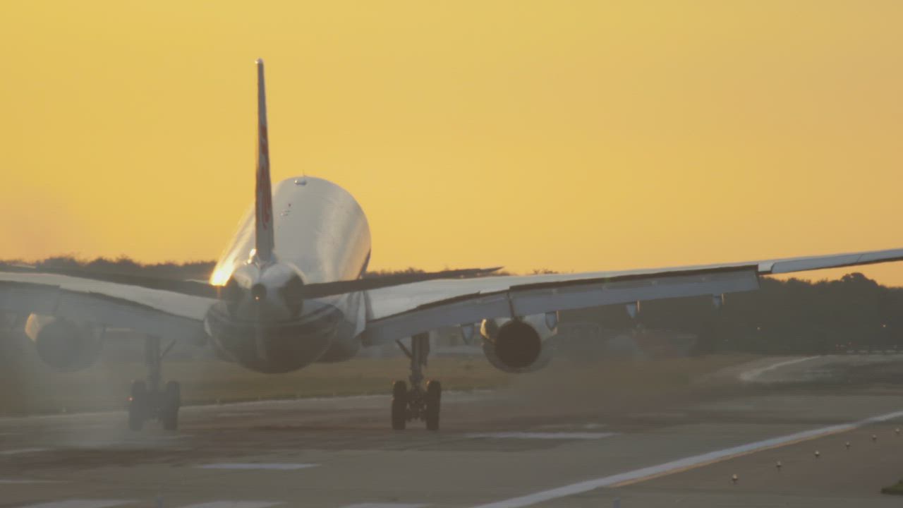 Airplane landing in slow motion in a yellow sky - Free Stock Video
