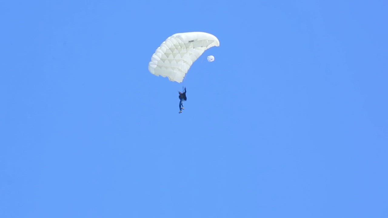 Man in white parachute falling down - Free Stock Video