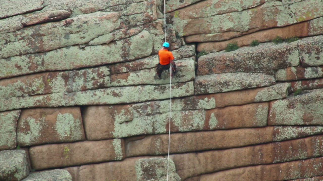 Man climbing down a rock - Free Stock Video
