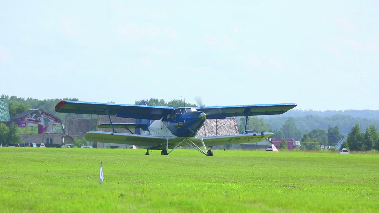 Biplane crossing the grass field - Free Stock Video