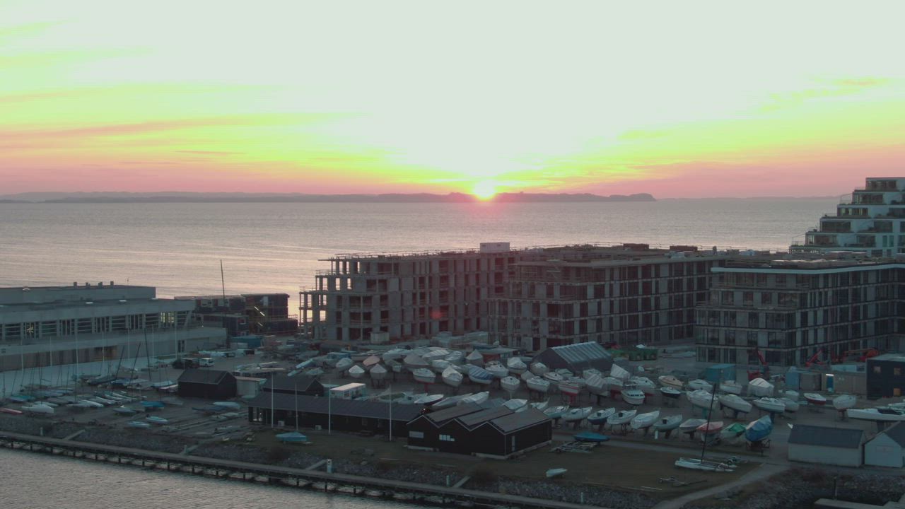 Buildings by the ocean at sunset - Free Stock Video