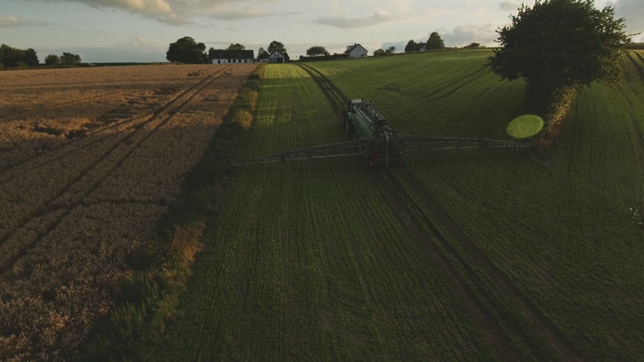 Tractor working near a farmhouse - Free Stock Video