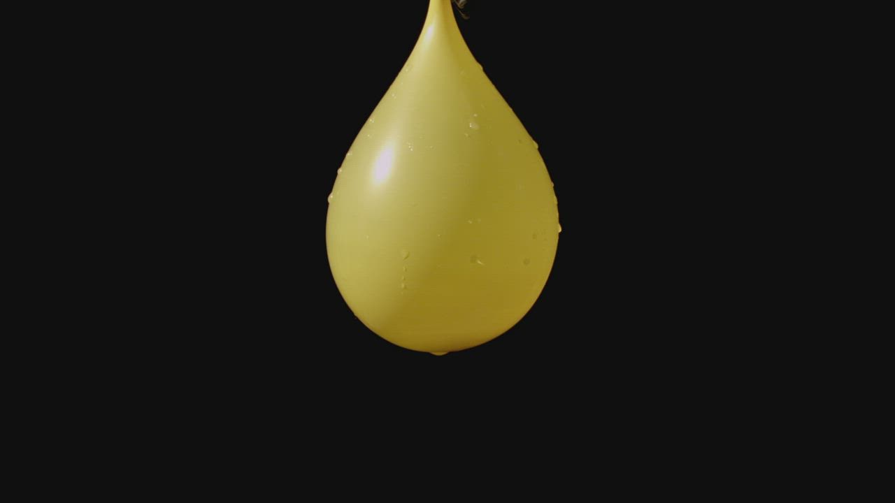 Balloon popping on a black background - Free Stock Video