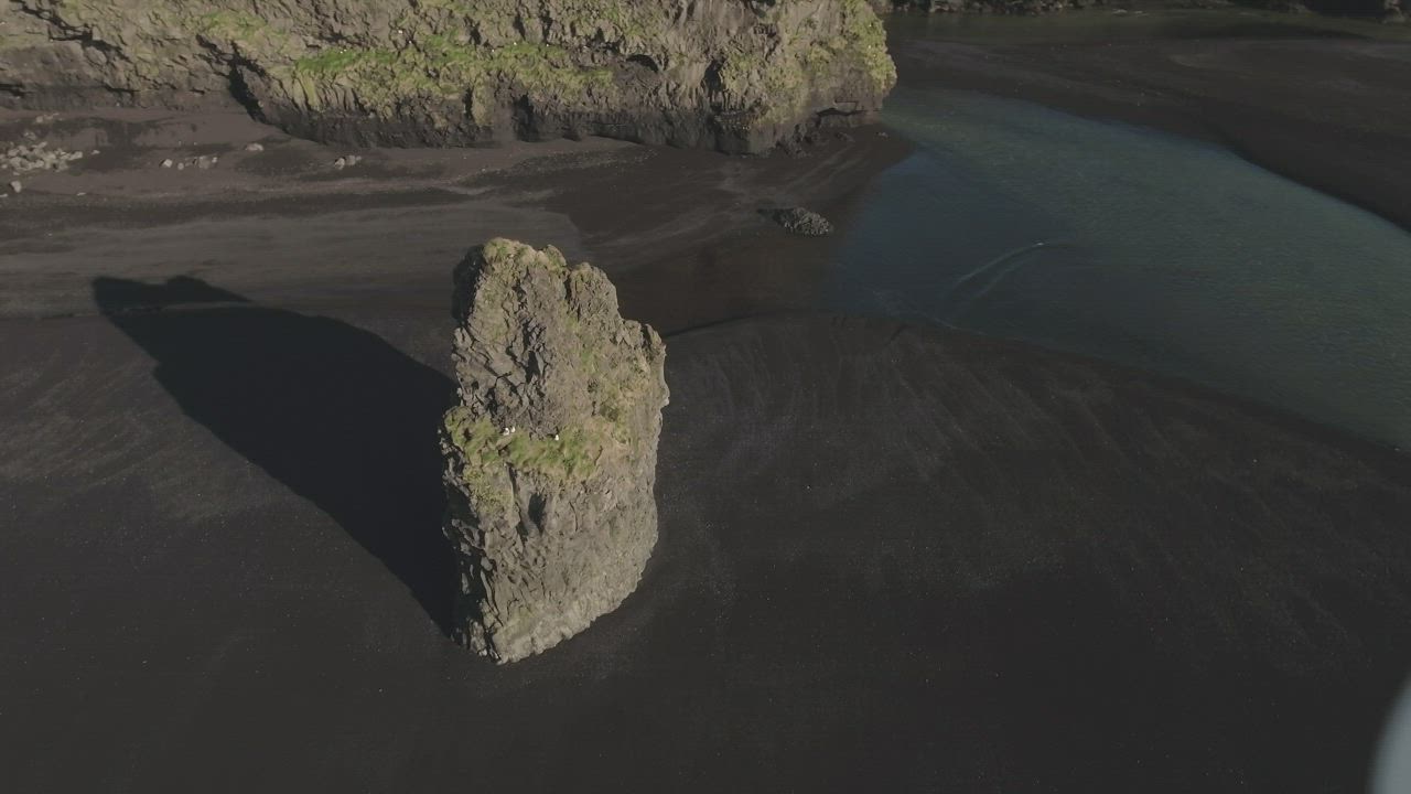 Black sand beach rock formation - Free Stock Video