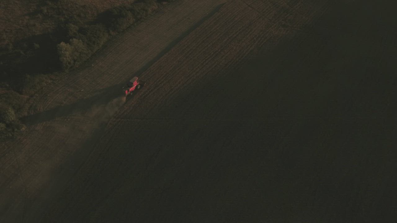 Tractor moving across a field - Free Stock Video