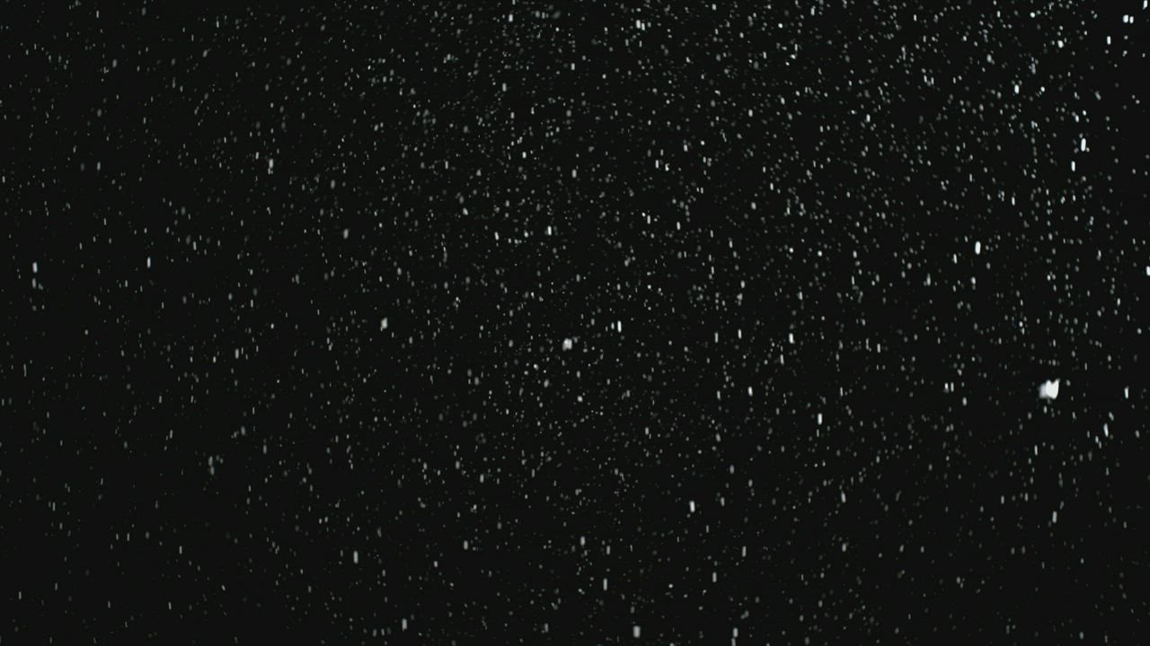 Texture of snow falling on black background - Free Stock Video
