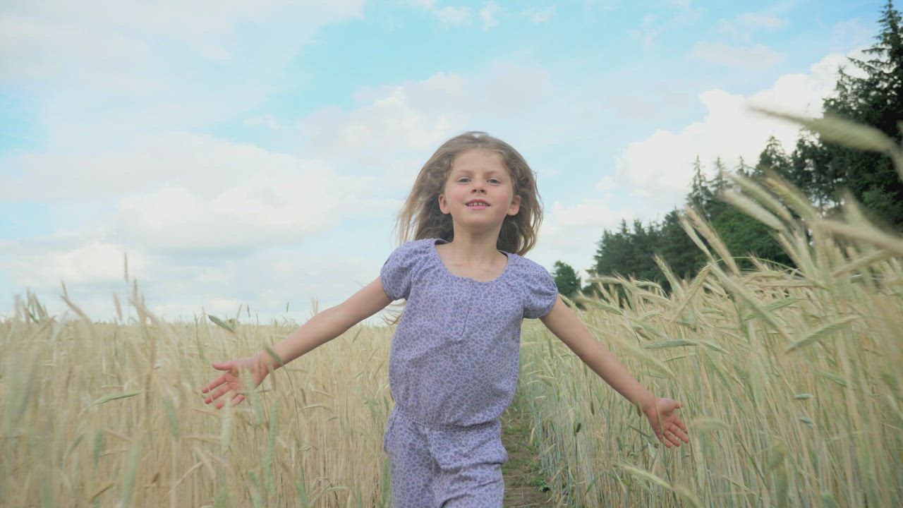 Happy little girl running through field - Free Stock Video