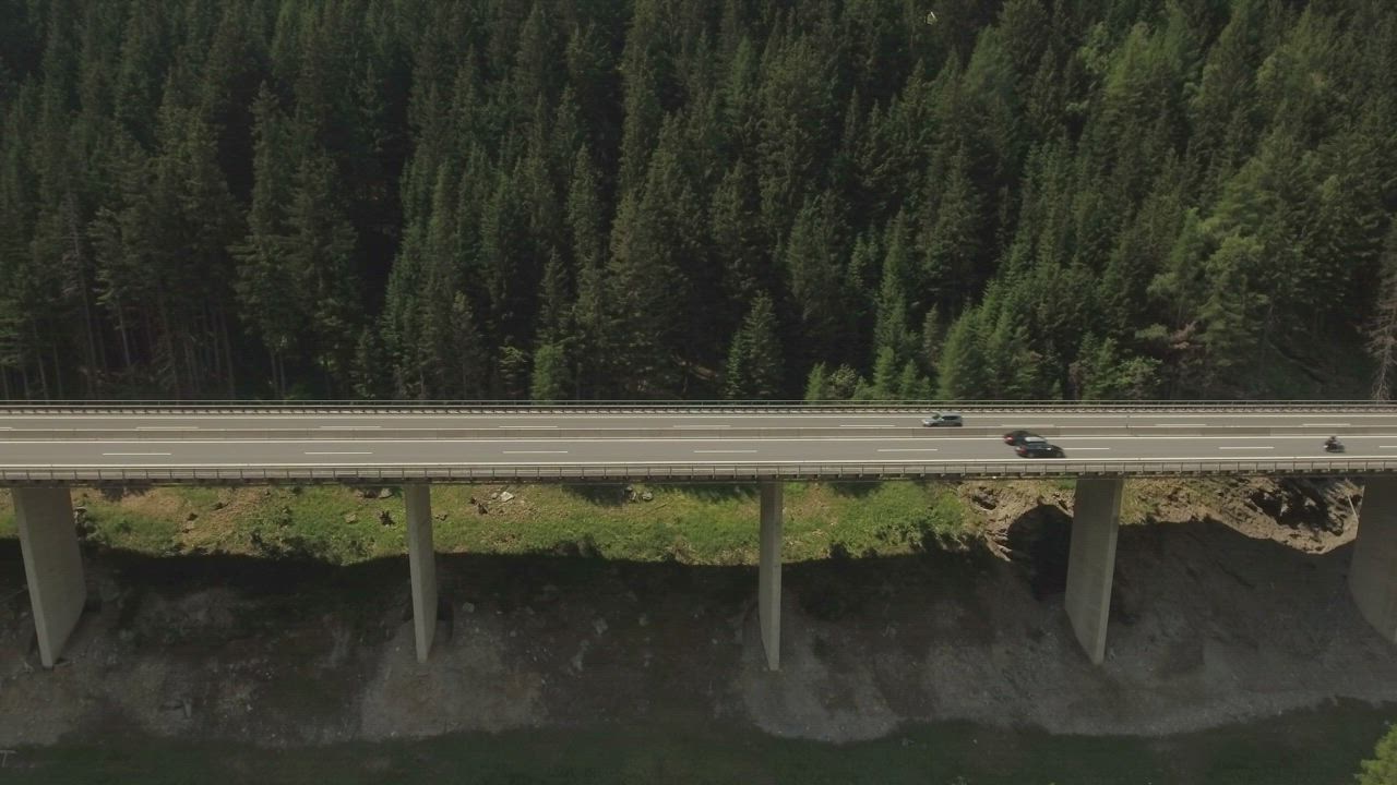 Flyover of tall mountain highway along river - Free Stock Video