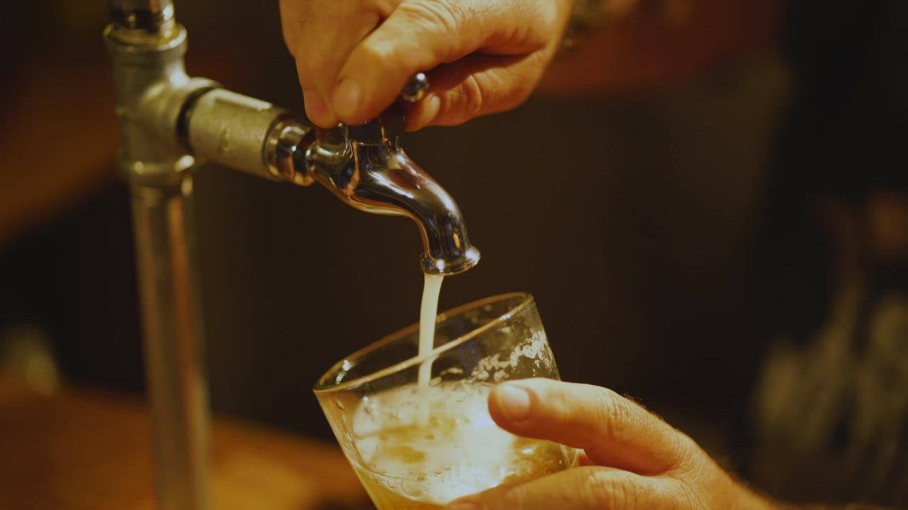 Bartender serving beer from a tap in a glass in the bar - Free Stock Video