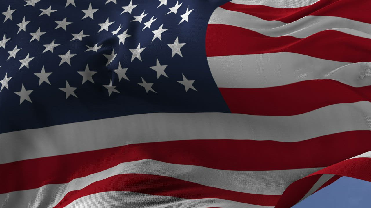 American flag waves in slow motion while zooming out - Free Stock Video