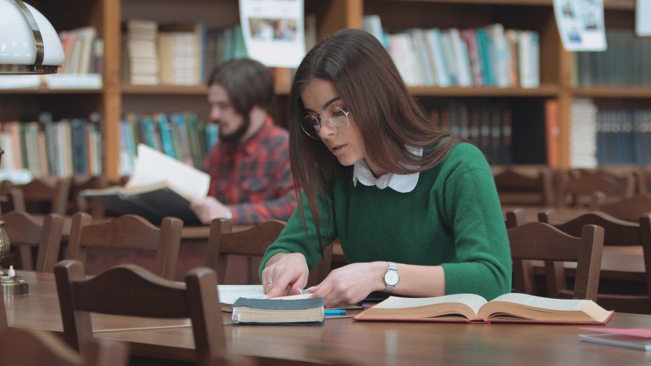 College student thinking in library - Free Stock Video