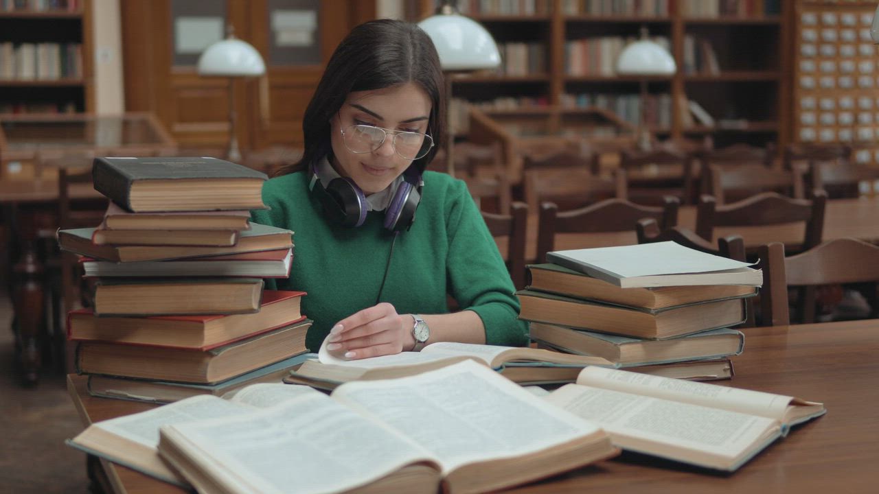 University student researching with books in library - Free Stock Video