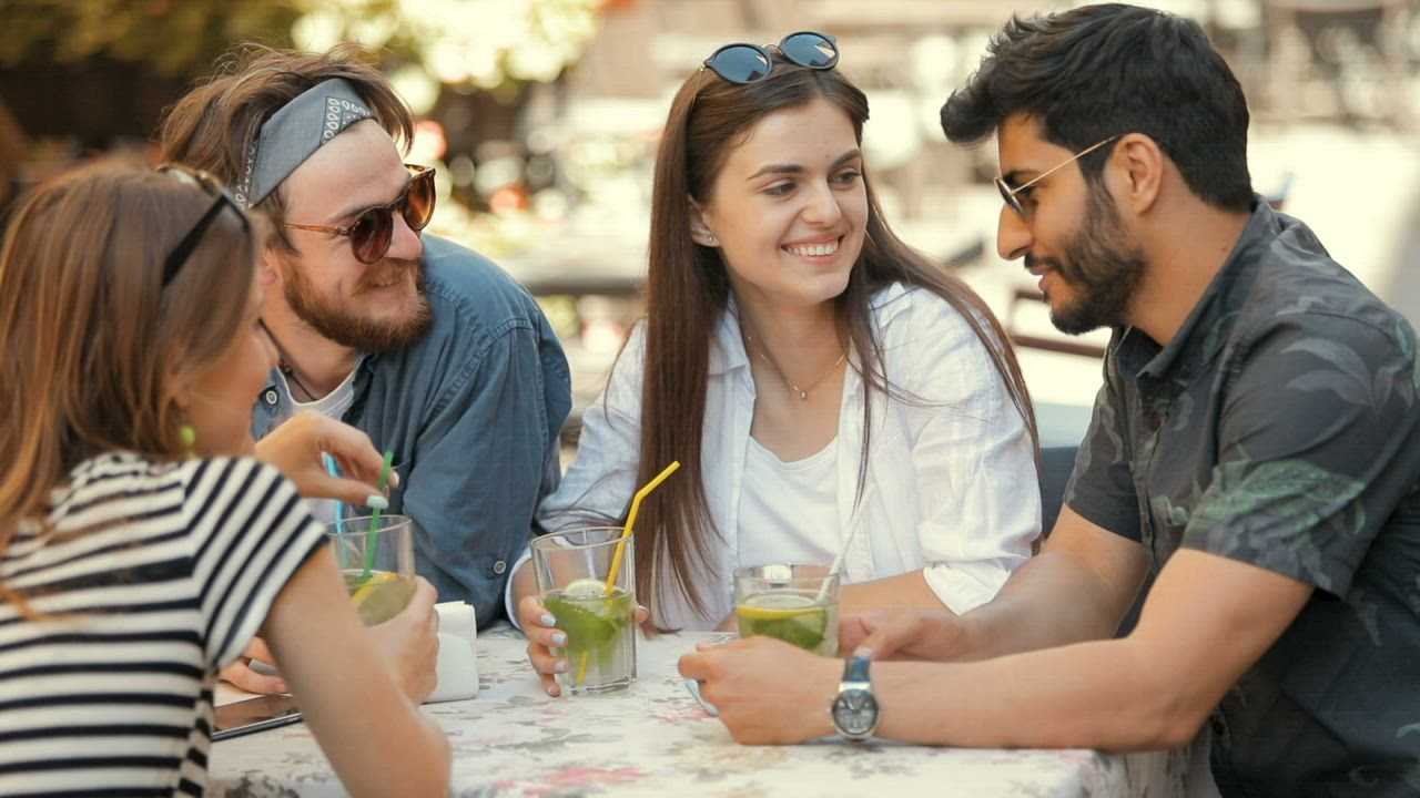 Happy friends chat while having drinks outdoors - Free Stock Video