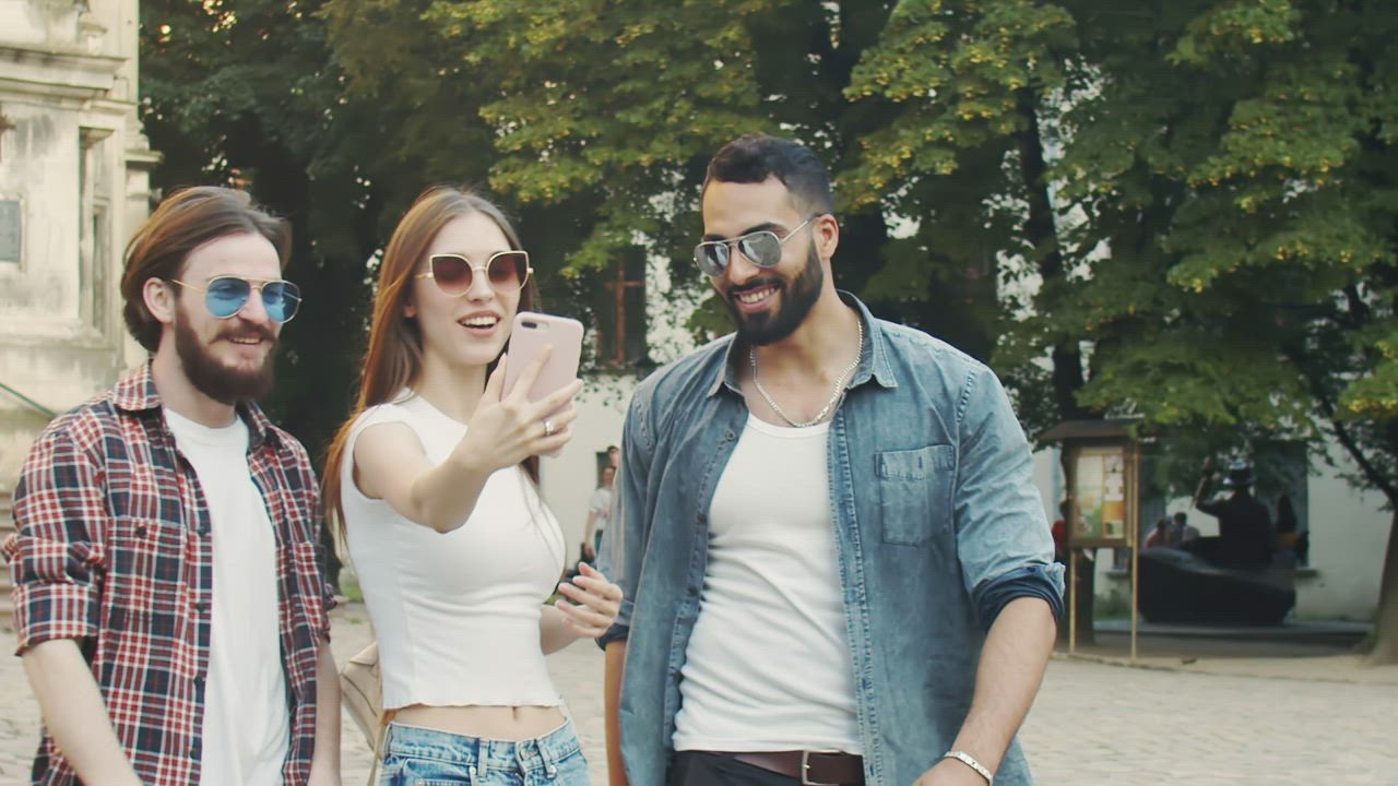 Friends say hello on video call while walking outdoors - Free Stock Video