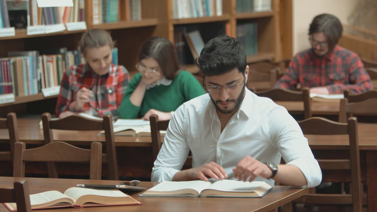 Man focused on study for exam in library - Free Stock Video