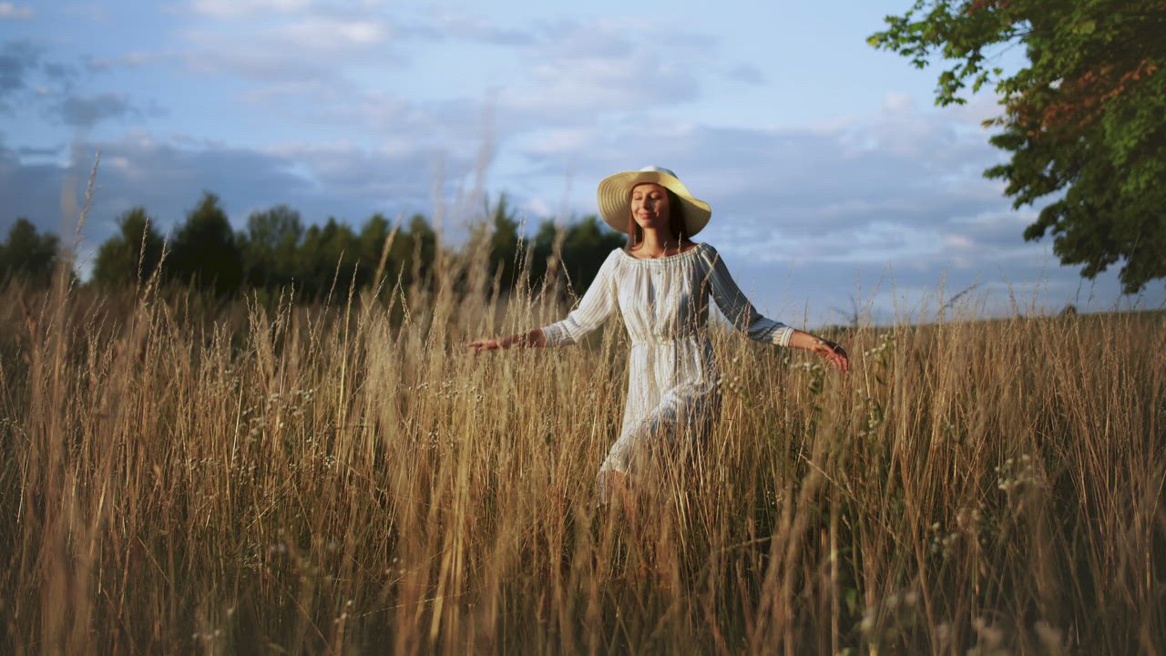 Cinematic of woman walking in field at sunset - Free Stock Video
