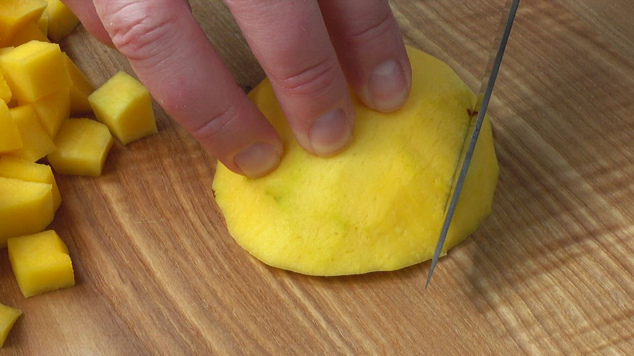 Cutting mango on a board, close up - Free Stock Video