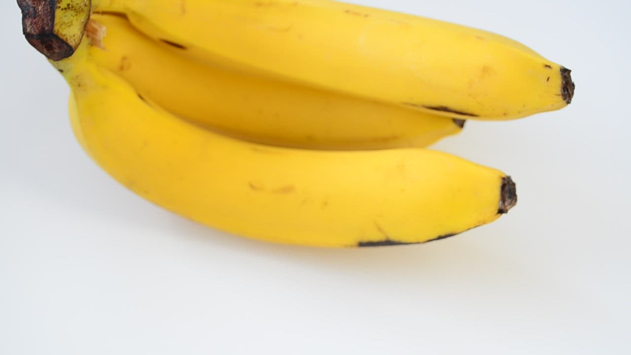 Banana on white background, spinning shot - Free Stock Video