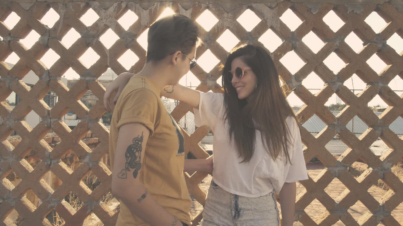 Couple caressing in front of fence - Free Stock Video