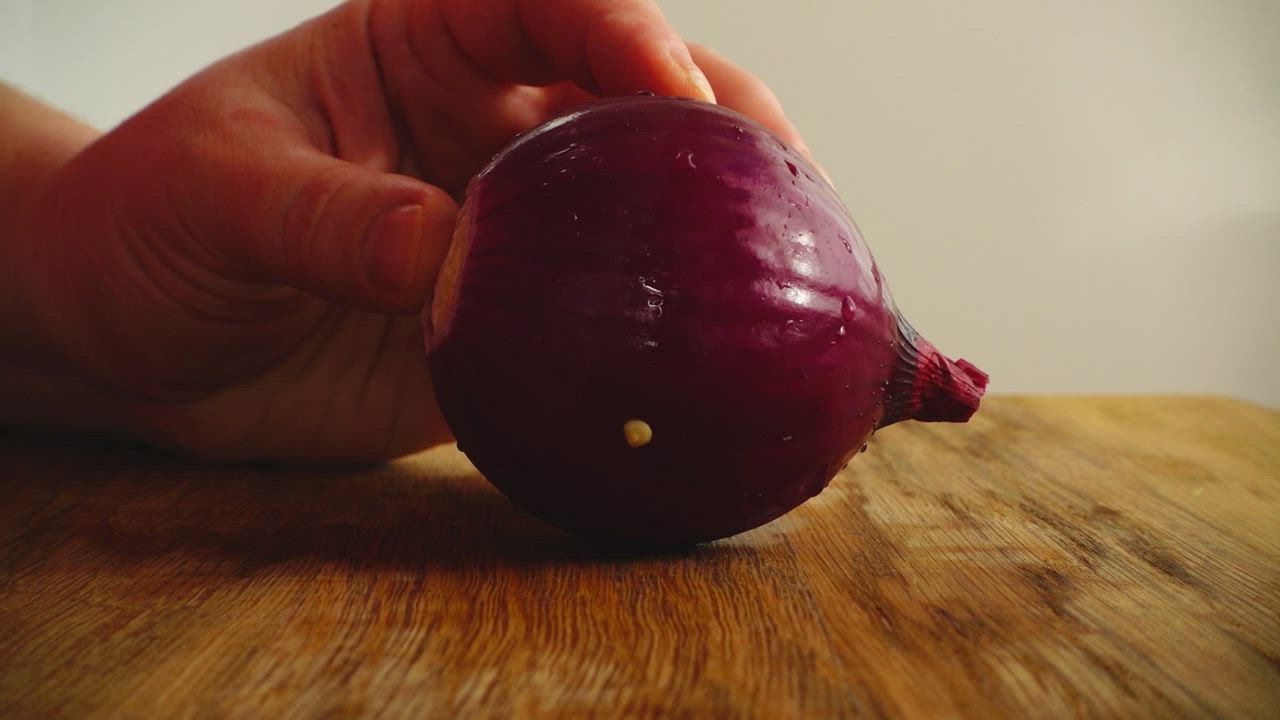 Splitting a purple onion in half - Free Stock Video
