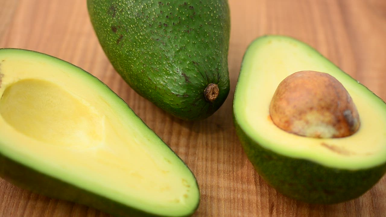 Avocados spinning on a kitchen table - Free Stock Video