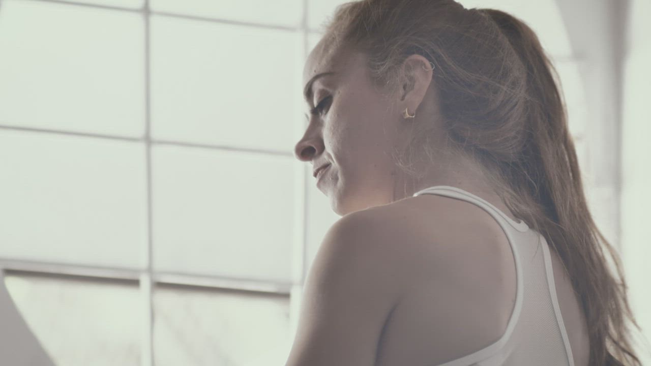 Woman stretching in front of window close up - Free Stock Video