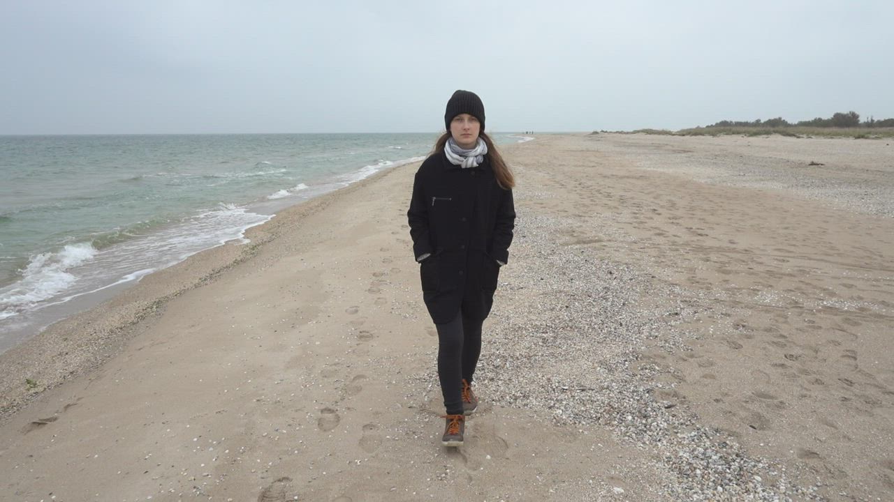 Woman walking on a cold beach - Free Stock Video